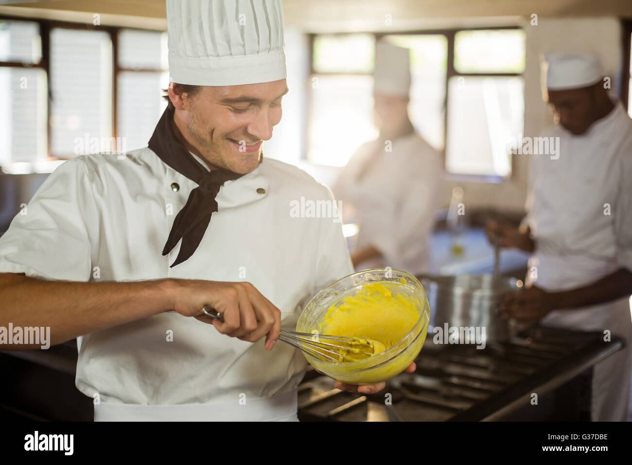 Smiling chef mixing dough Stock Photo - Alamy