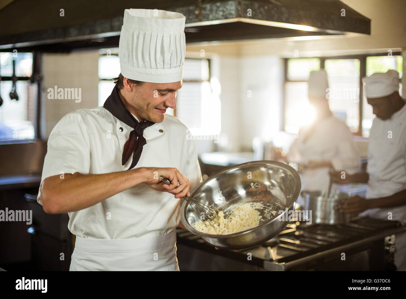 Smiling chef mixing dough Stock Photo - Alamy