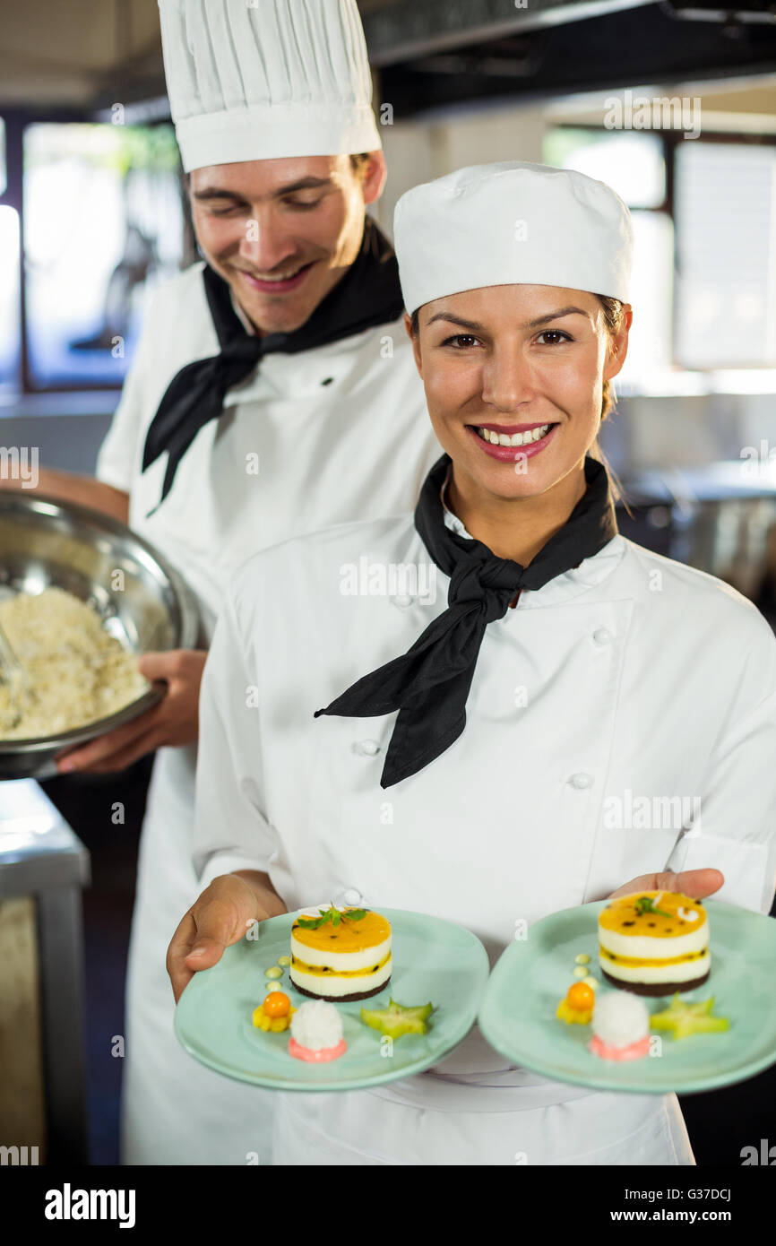 Portrait of female chef presenting dessert plates Stock Photo - Alamy