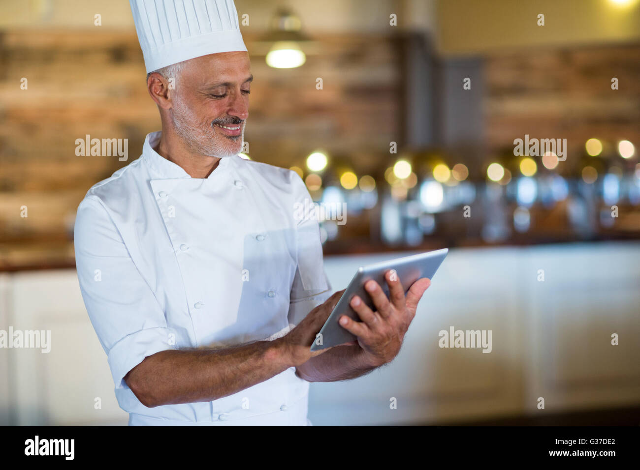 Smiling chef using digital tablet Stock Photo - Alamy