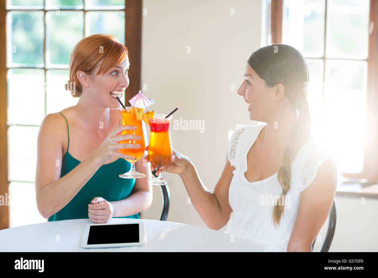 Two women drinking cocktail Stock Photo - Alamy