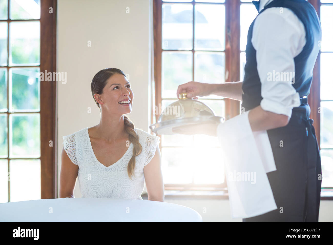 Waiter serving food to women in restaurant Stock Photo - Alamy