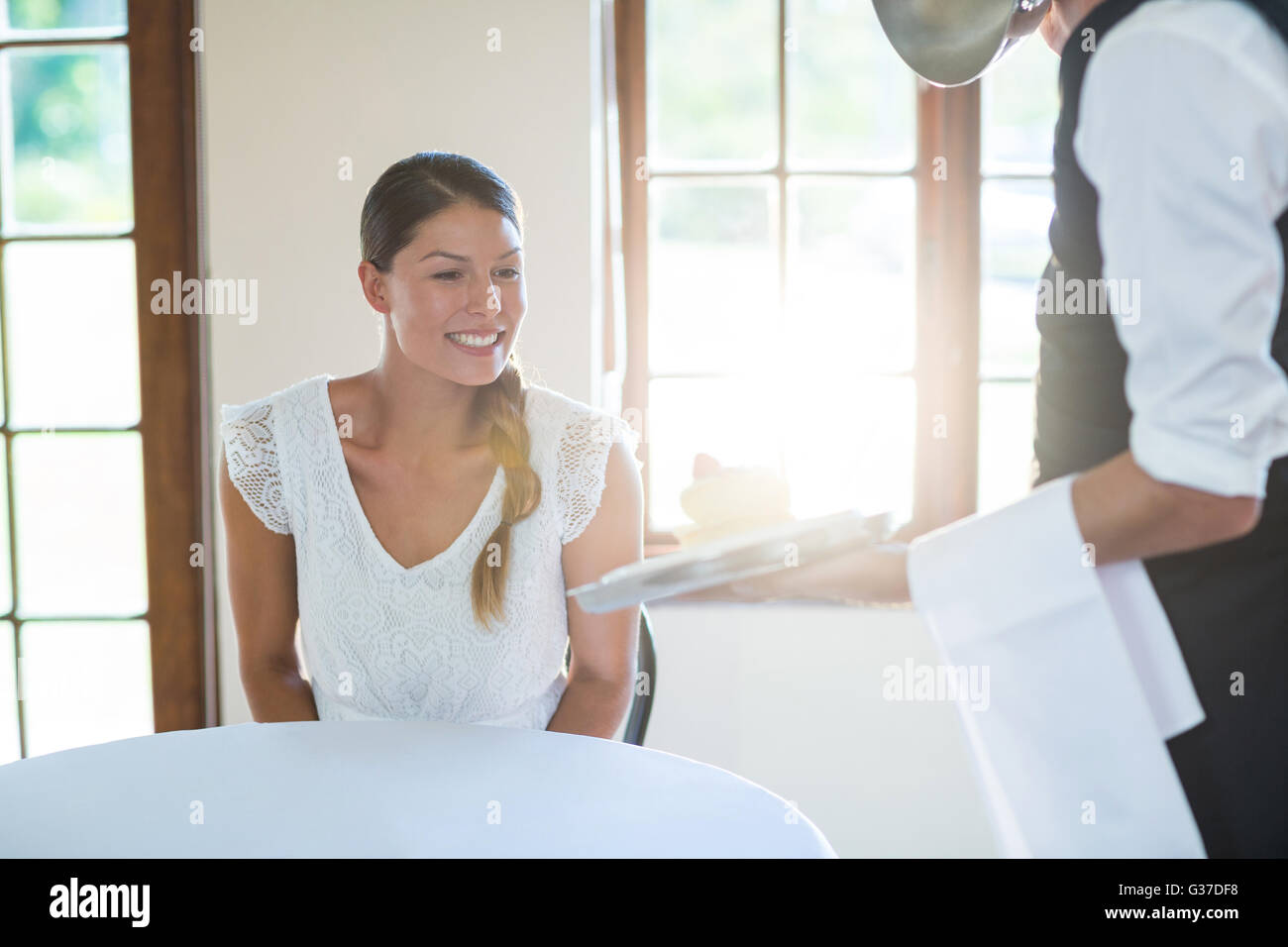 Waiter serving food to women in restaurant Stock Photo - Alamy