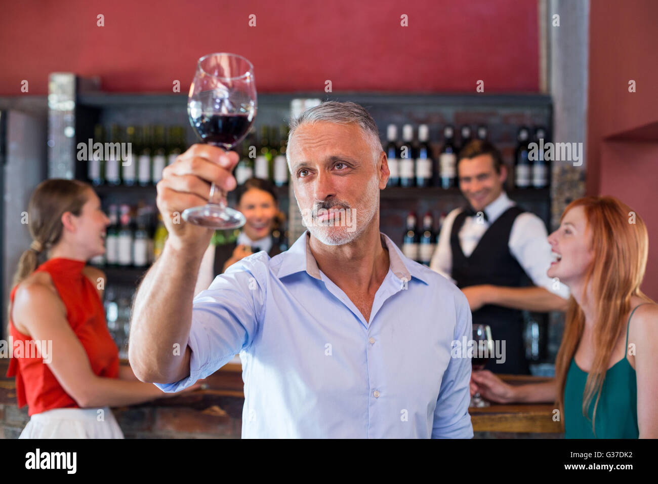 Man toasting with a glass of red wine in a bar Stock Photo - Alamy
