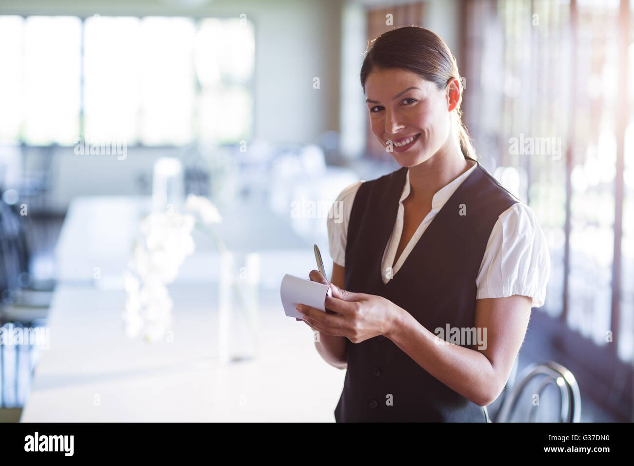 Portrait of smiling waitress taking order Stock Photo - Alamy