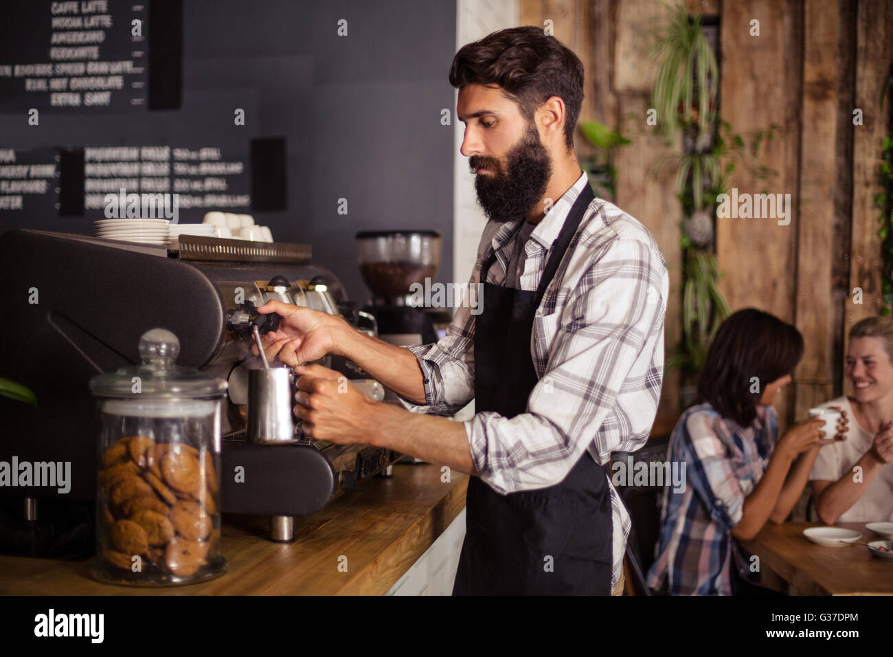 Waiter using a coffee machine Stock Photo - Alamy
