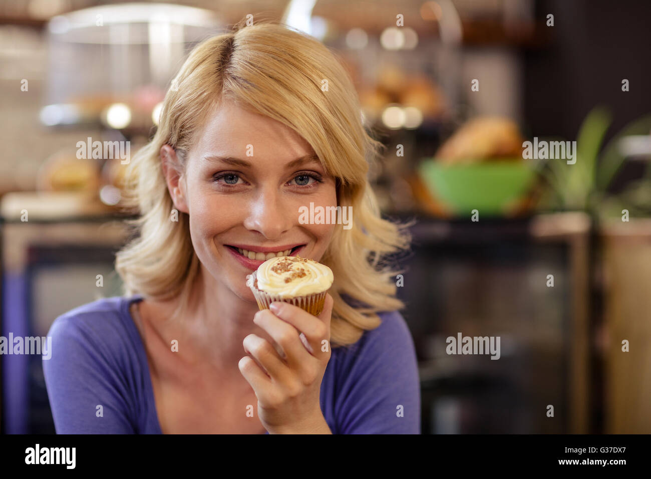 Young woman holding a muffin hi-res stock photography and images - Alamy
