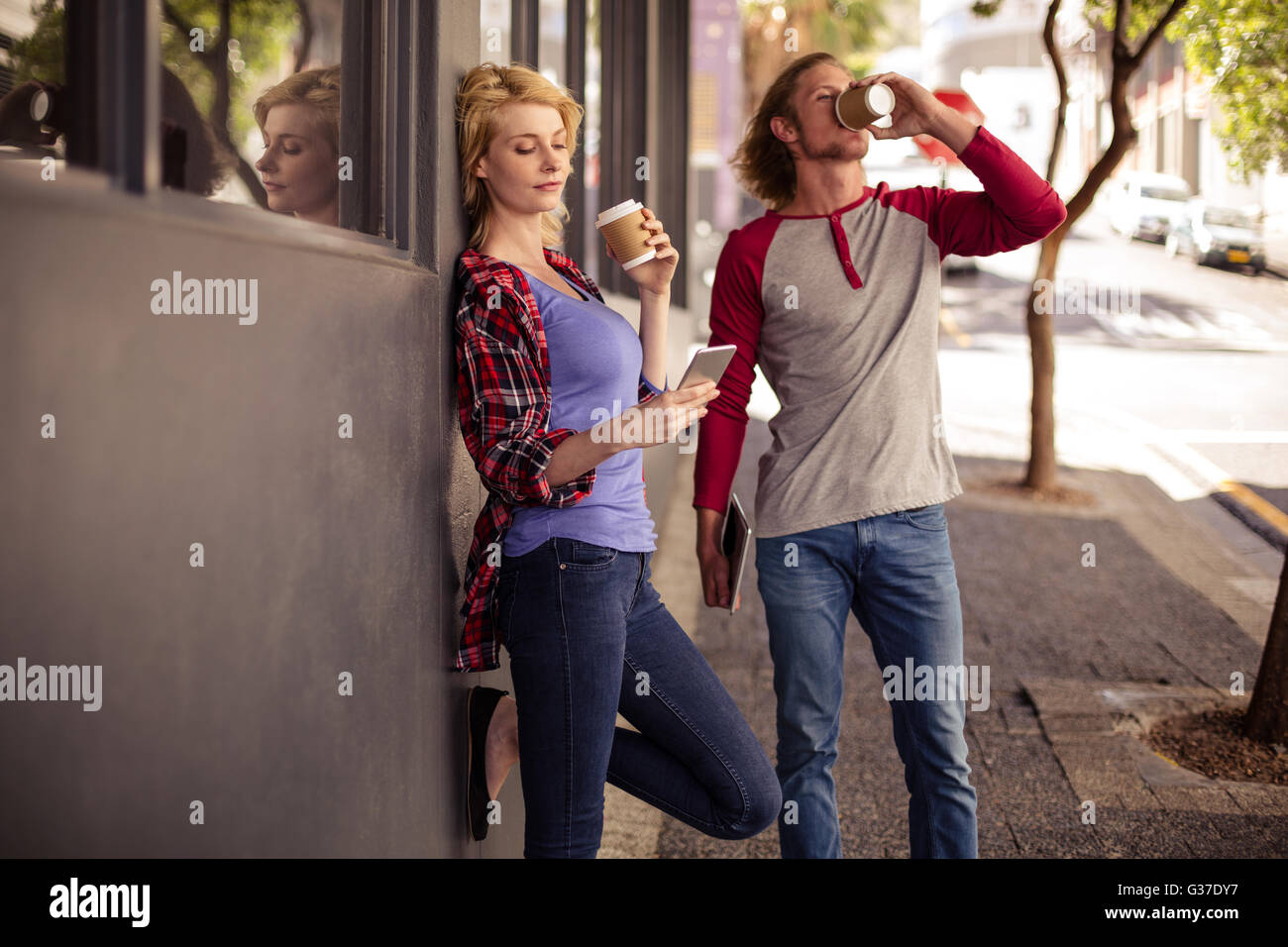 Customers using a smartphone and drinking coffee Stock Photo - Alamy