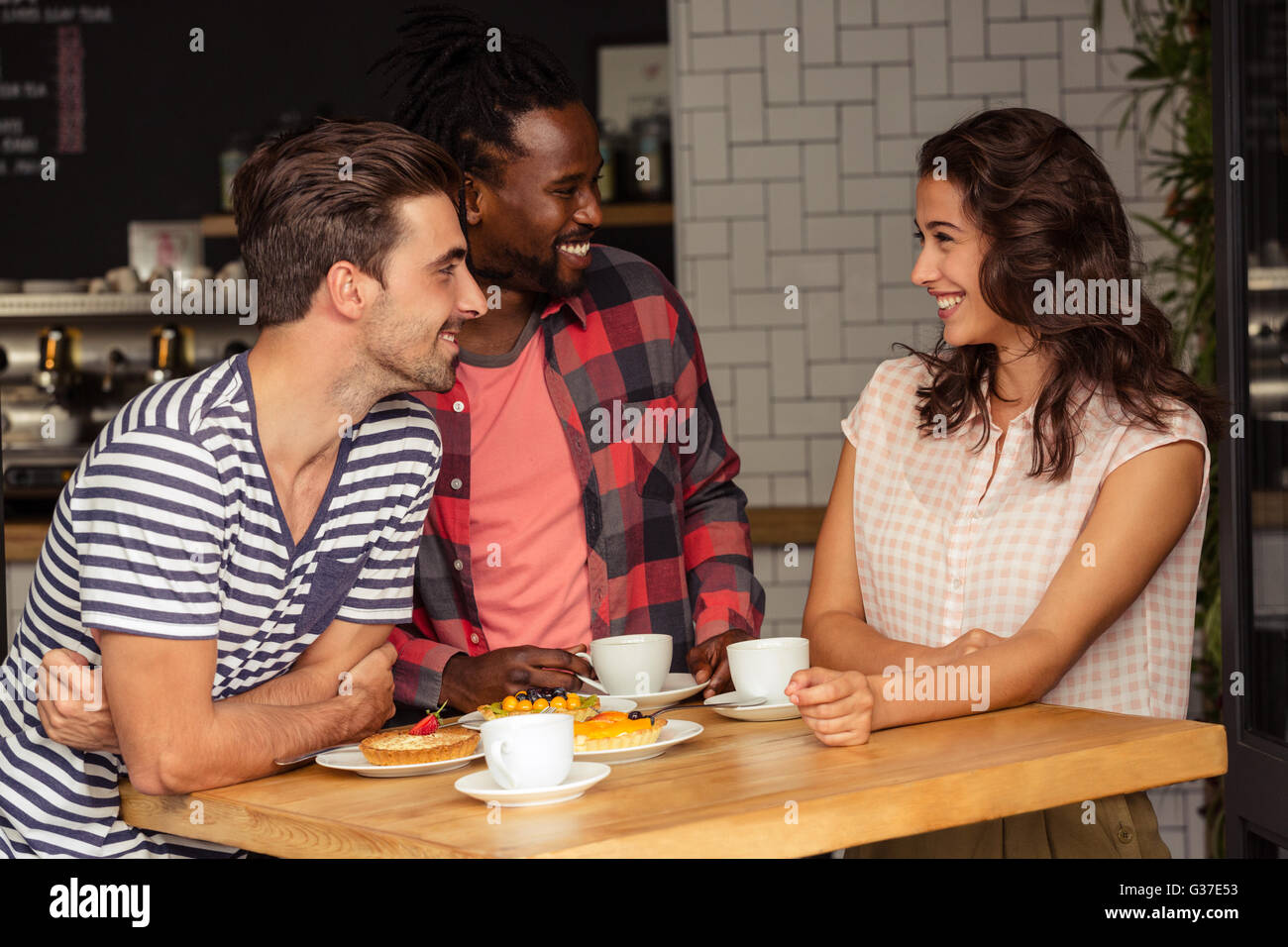 Friends talking together and smiling Stock Photo - Alamy