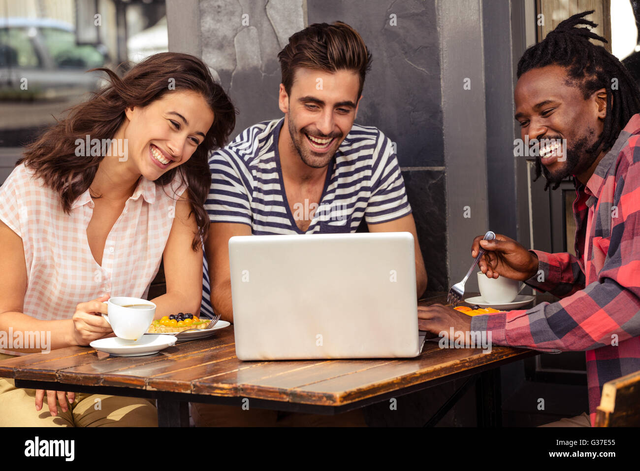 Friends using a laptop Stock Photo - Alamy