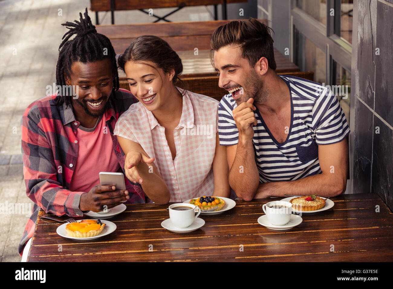 Friends using smartphone together Stock Photo - Alamy