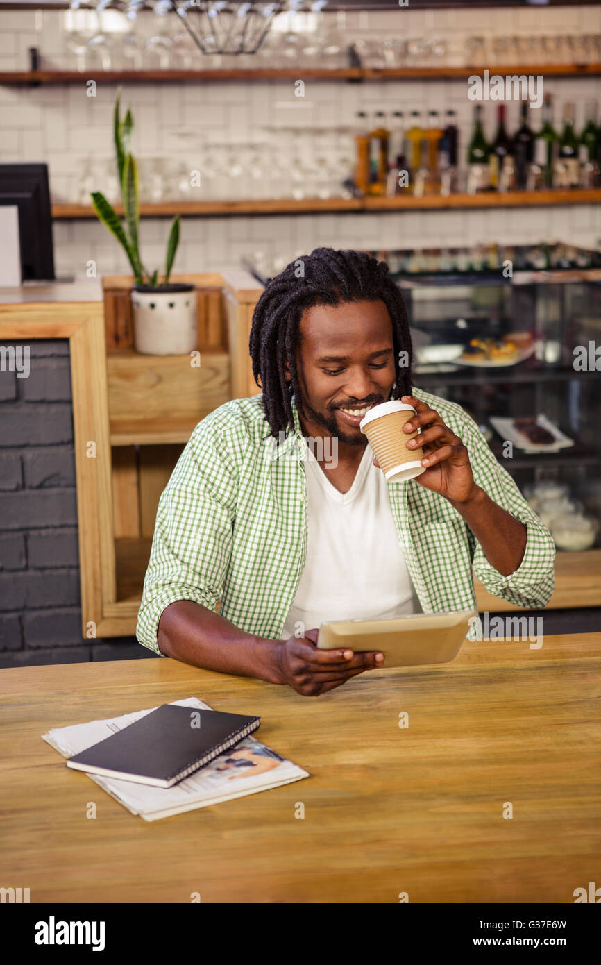 Young man using digital tablet in cafeteria Stock Photo - Alamy