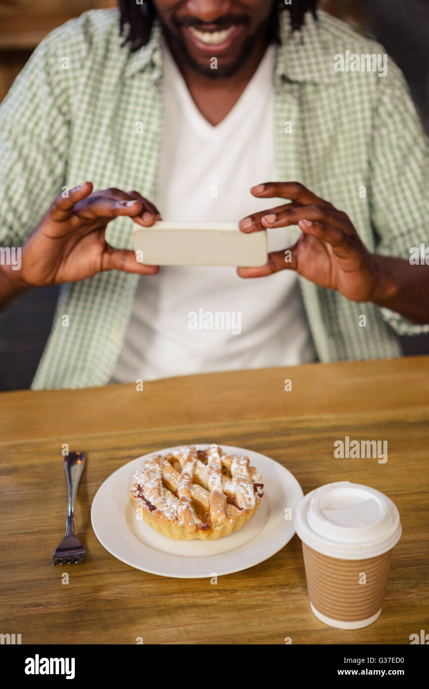 Man taking picture of a cake alone Stock Photo - Alamy