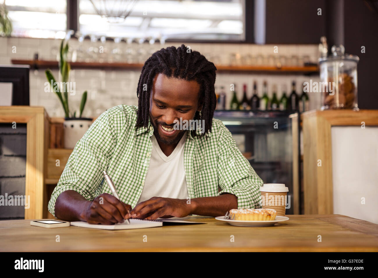 Man writing in a notebook Stock Photo - Alamy