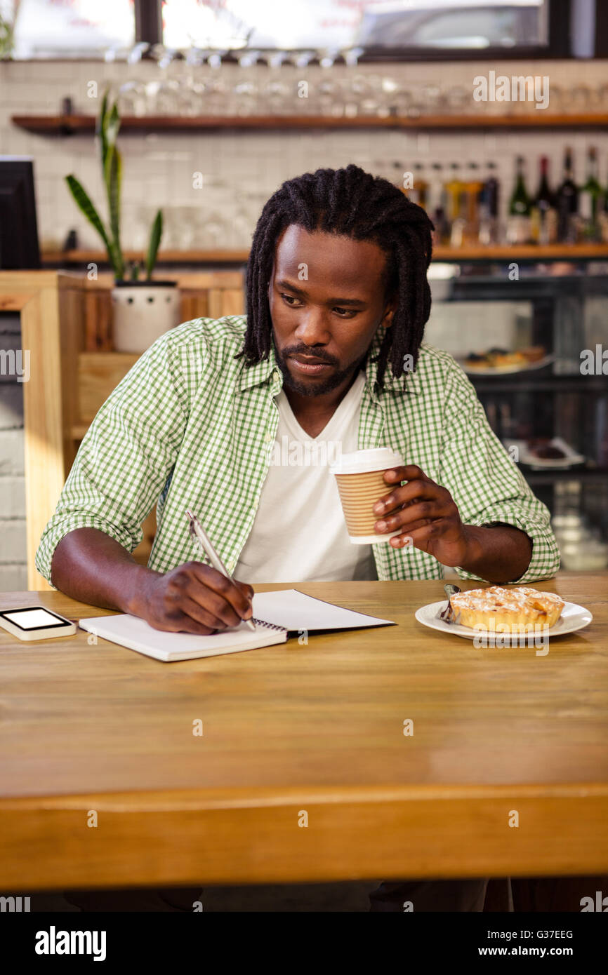 Man writing in a notebook Stock Photo - Alamy