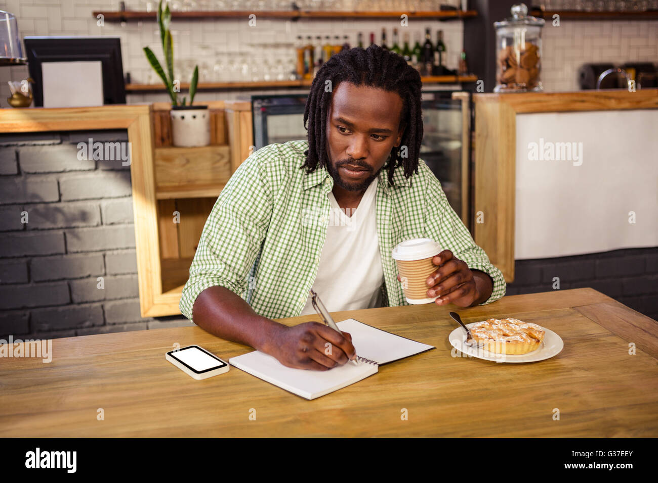 Man writing in a notebook Stock Photo - Alamy