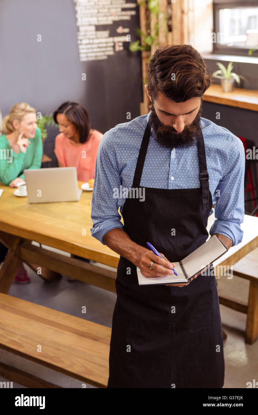 Waiter taking order in his book Stock Photo - Alamy