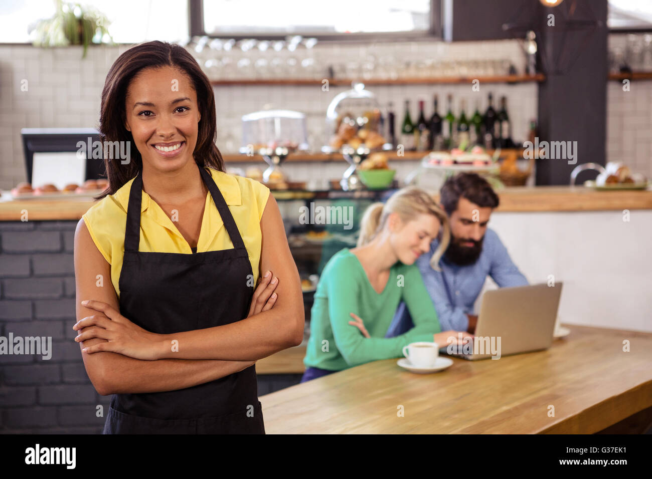 Waitress standing with arms crossed Stock Photo - Alamy
