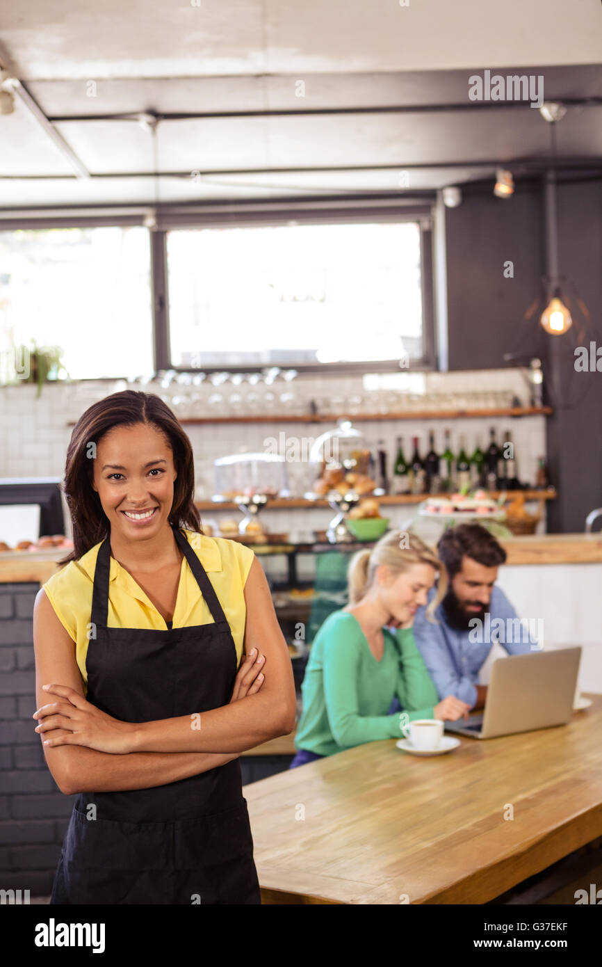 Waitress standing with arms crossed Stock Photo - Alamy