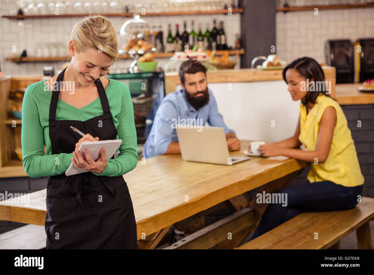 Waitress taking order on a notebook Stock Photo - Alamy