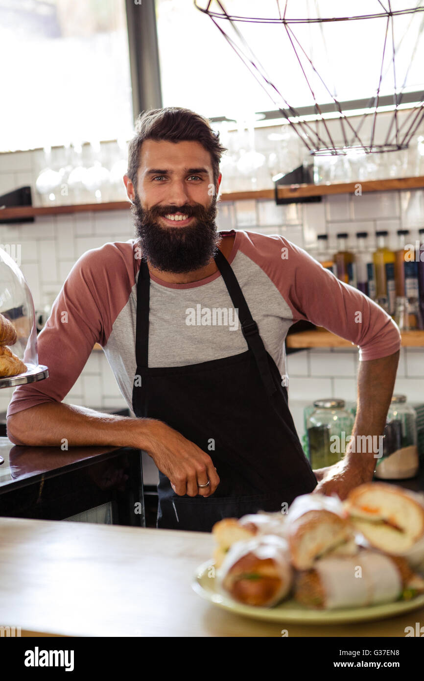 Waiter leaning against counter Stock Photo - Alamy