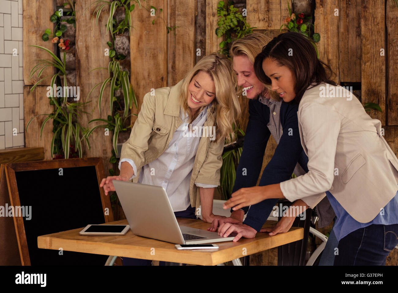 Friends using a laptop Stock Photo - Alamy