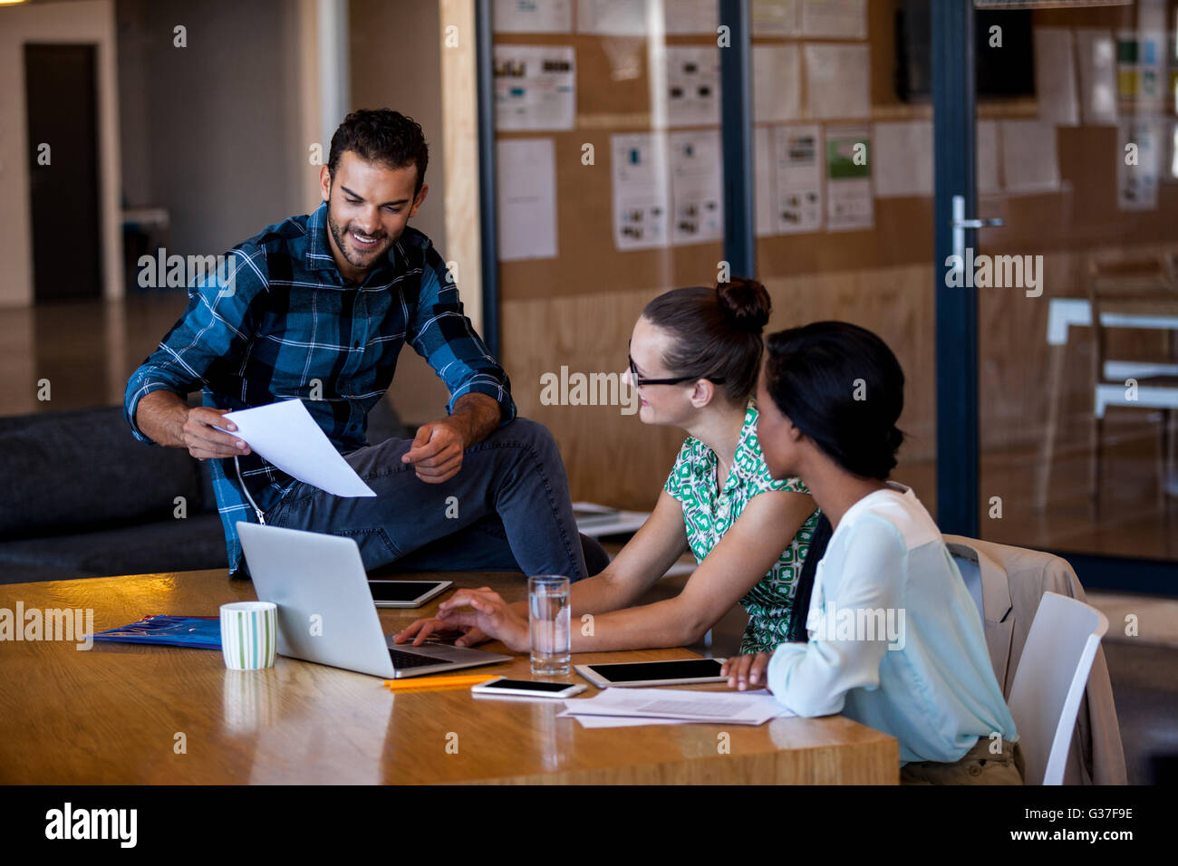 Businessman showing a paper to his team Stock Photo - Alamy