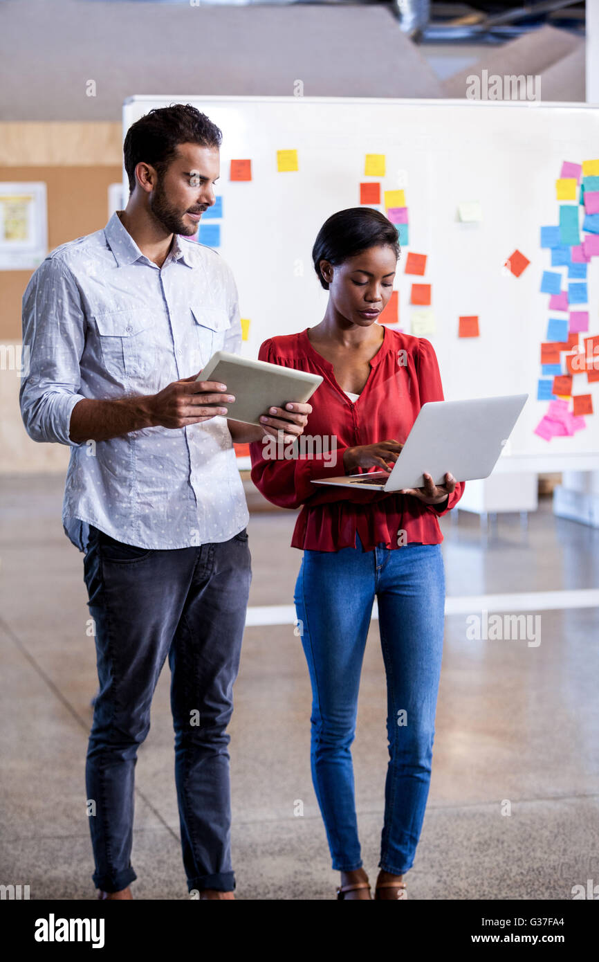 Coworkers walking with laptop and tablet computer Stock Photo - Alamy
