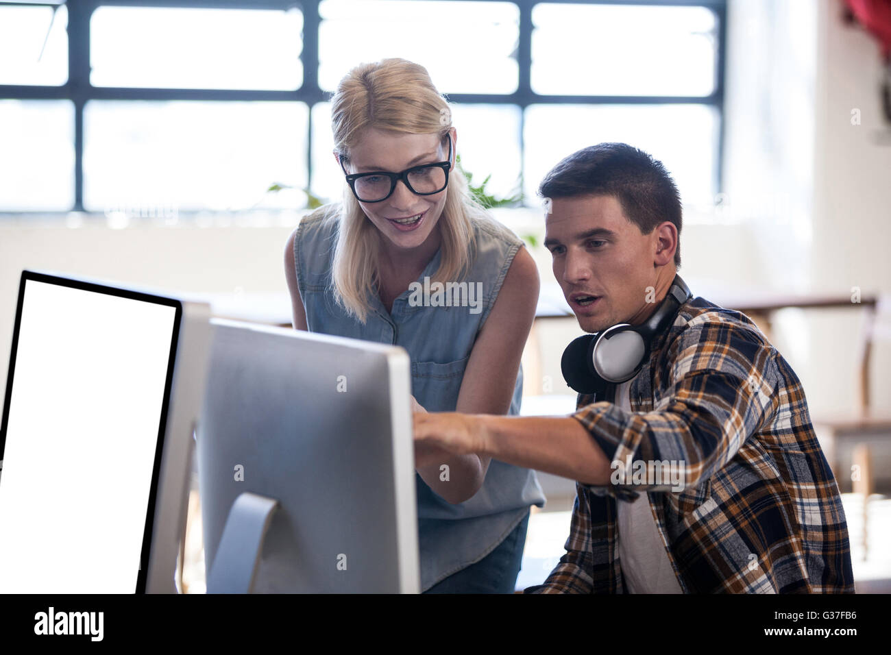 Coworkers pointing a computer Stock Photo - Alamy