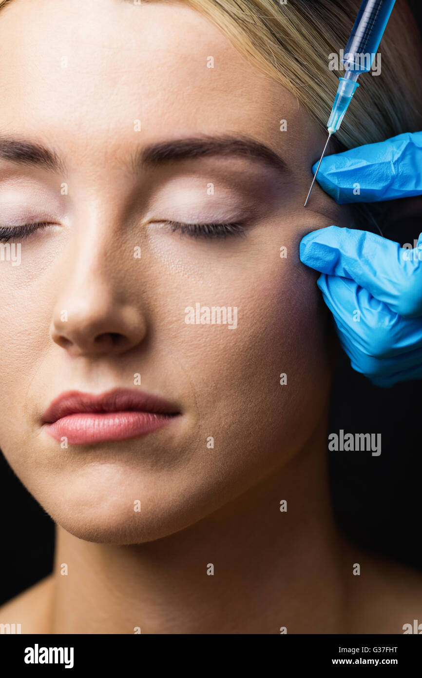 Woman receiving botox injection on her forehead Stock Photo - Alamy