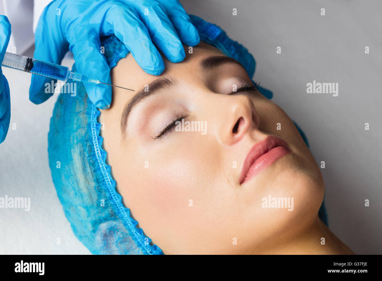 Woman receiving botox injection on her forehead Stock Photo - Alamy