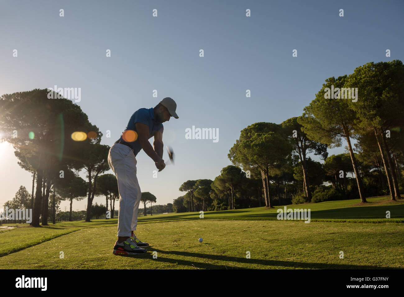 golf player hitting shot with club on course at beautiful morning with ...