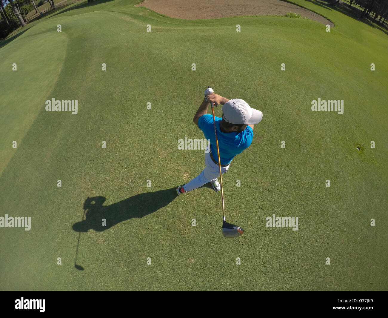 top view of golf player hitting shot with club on course at beautiful ...