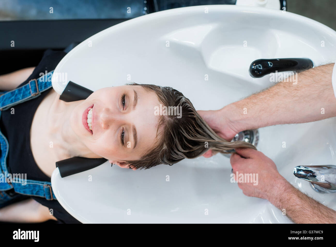 Hairdresser's hands washing woman's hair in salon. Top view Stock Photo ...