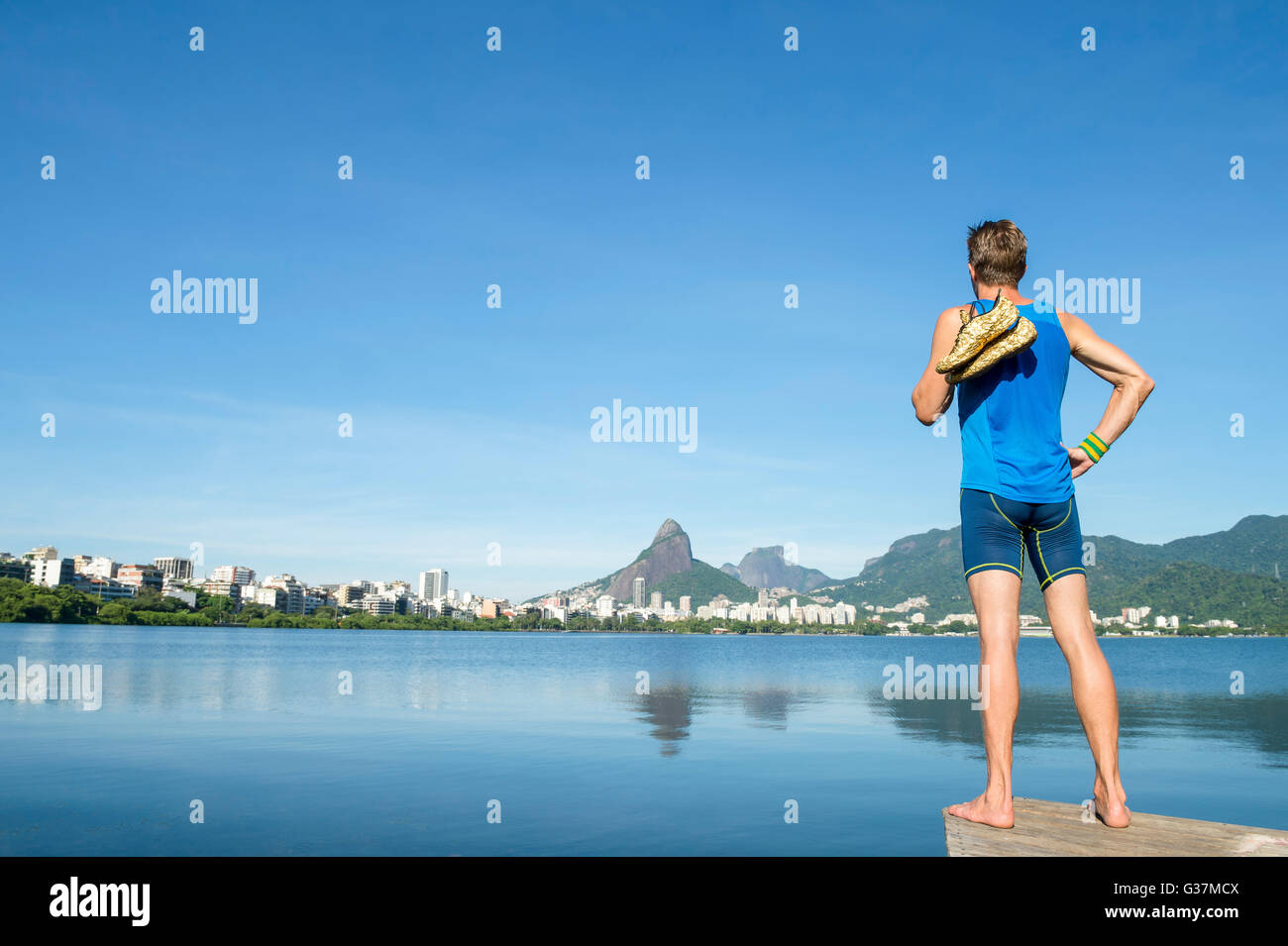 Brazilian athlete holding gold running shoes over his shoulder standing ...