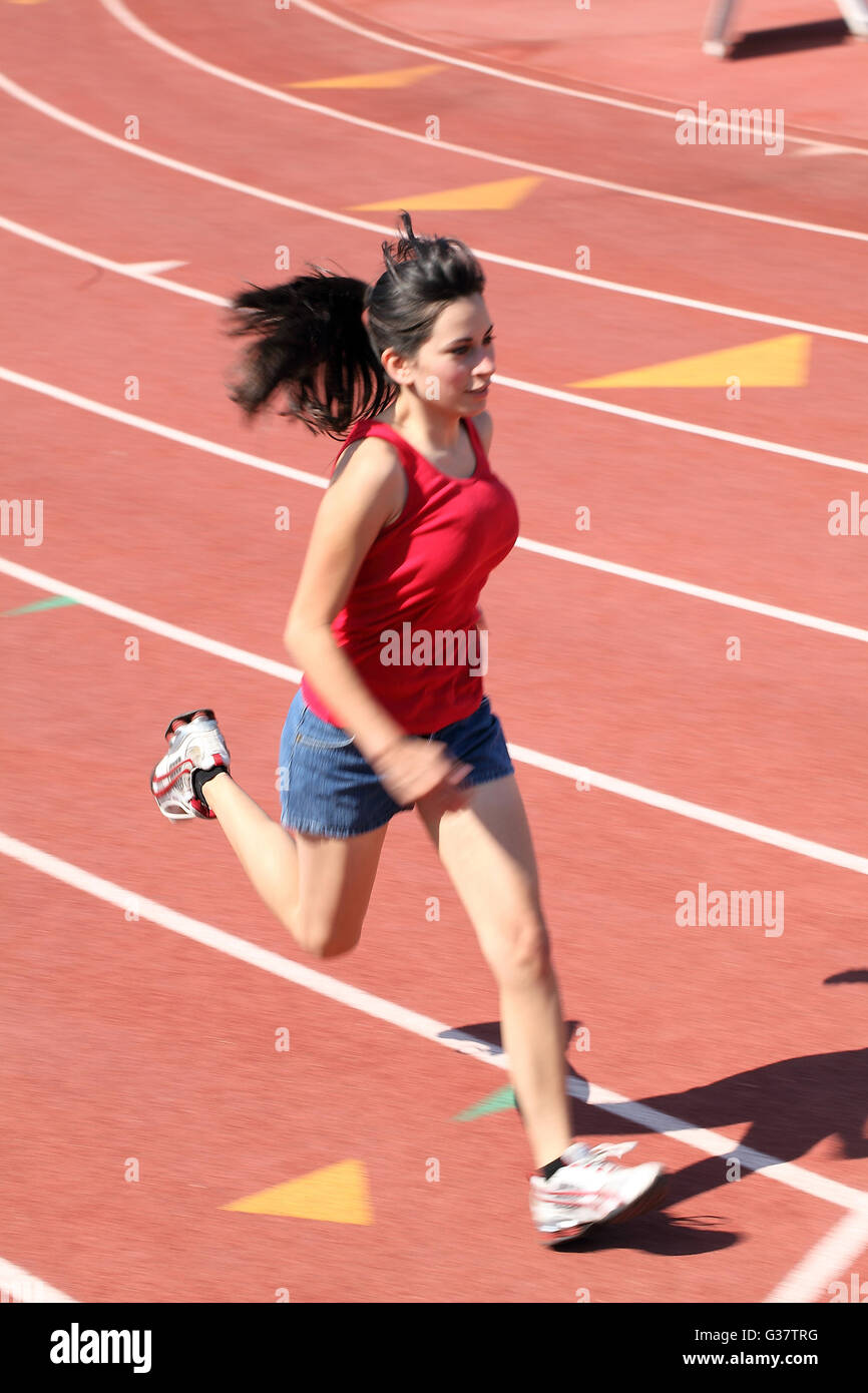 Young Hispanic teen girl running on track Stock Photo - Alamy