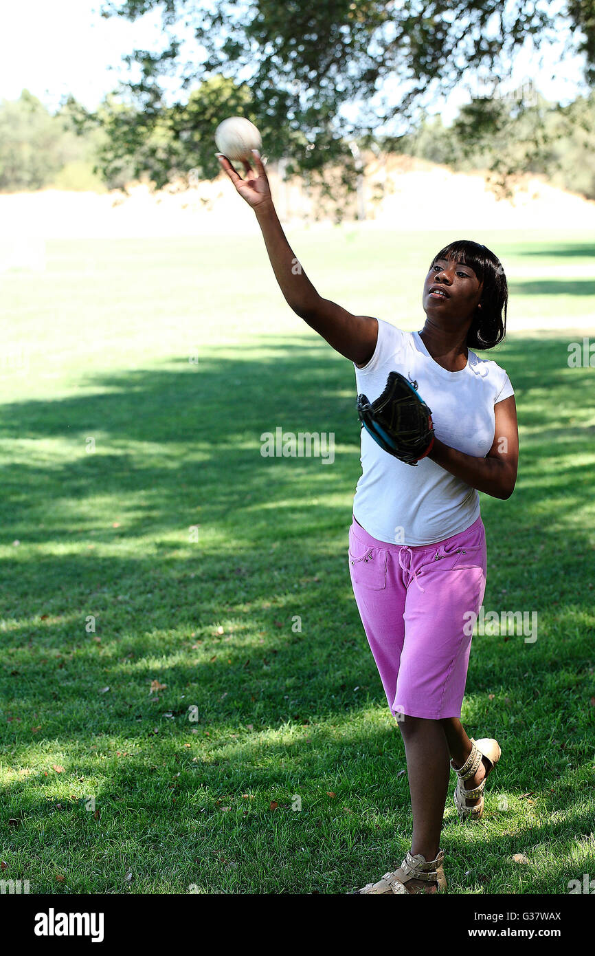 Black Woman Casual Clothes Throwing Ball in Park Stock Photo - Alamy