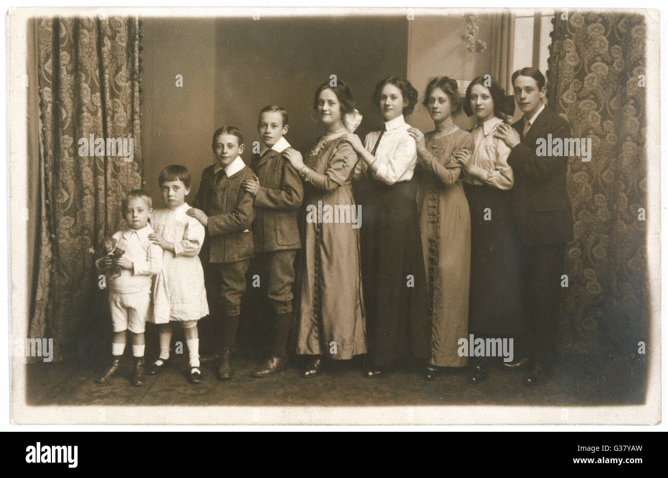 A mother and her eight children stand in a line in descending order ...