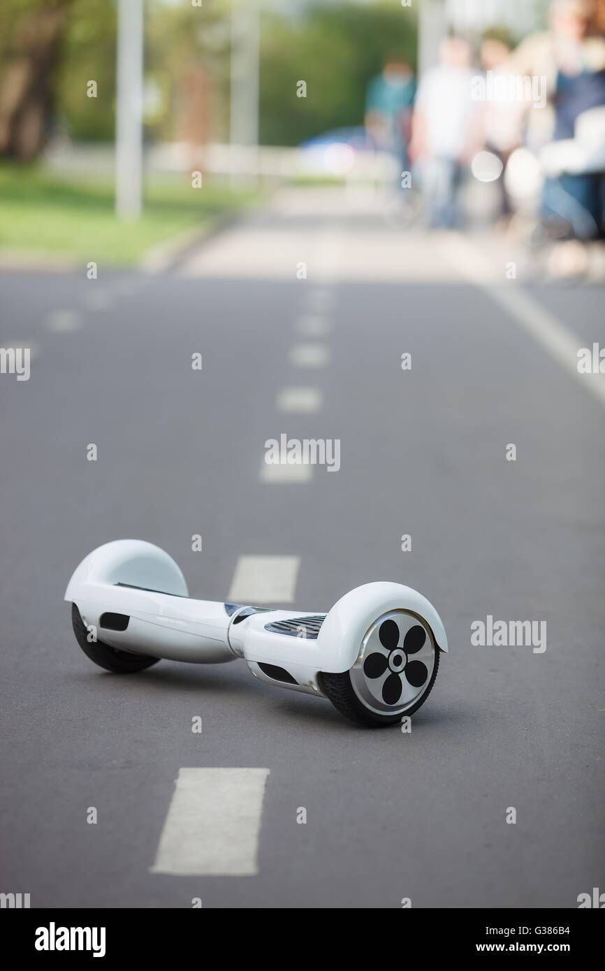 eWhite Electric mini hover board scooter on asphalt road. Eco city ...