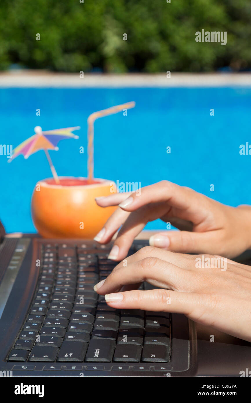 : Female hands on laptop keyboard at the poolside Stock Photo - Alamy