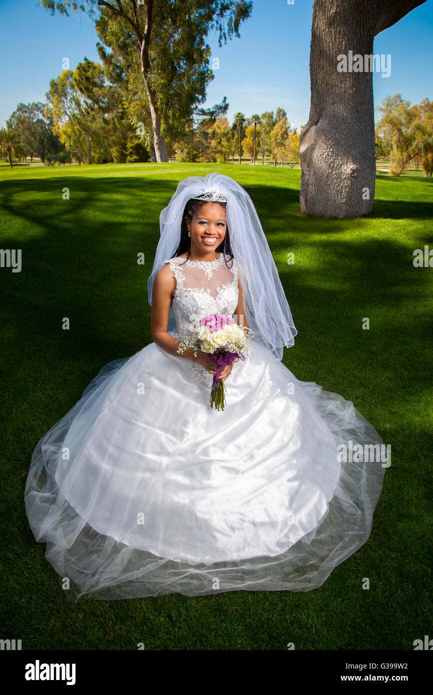 A beautiful, African American bride kneels for a portrait before her ...