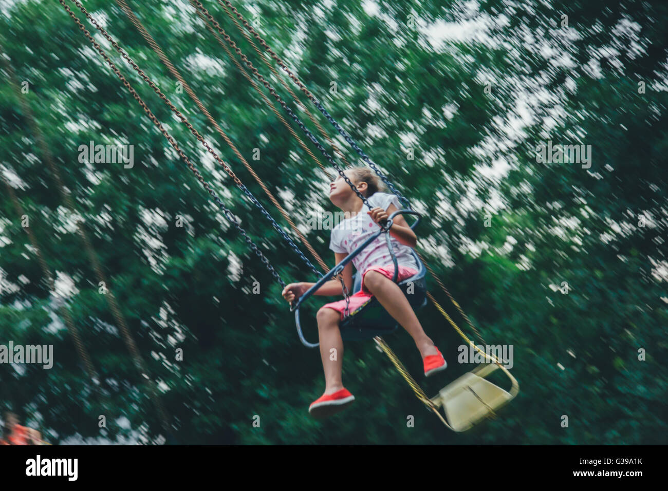 girl riding on chained carousel Stock Photo - Alamy