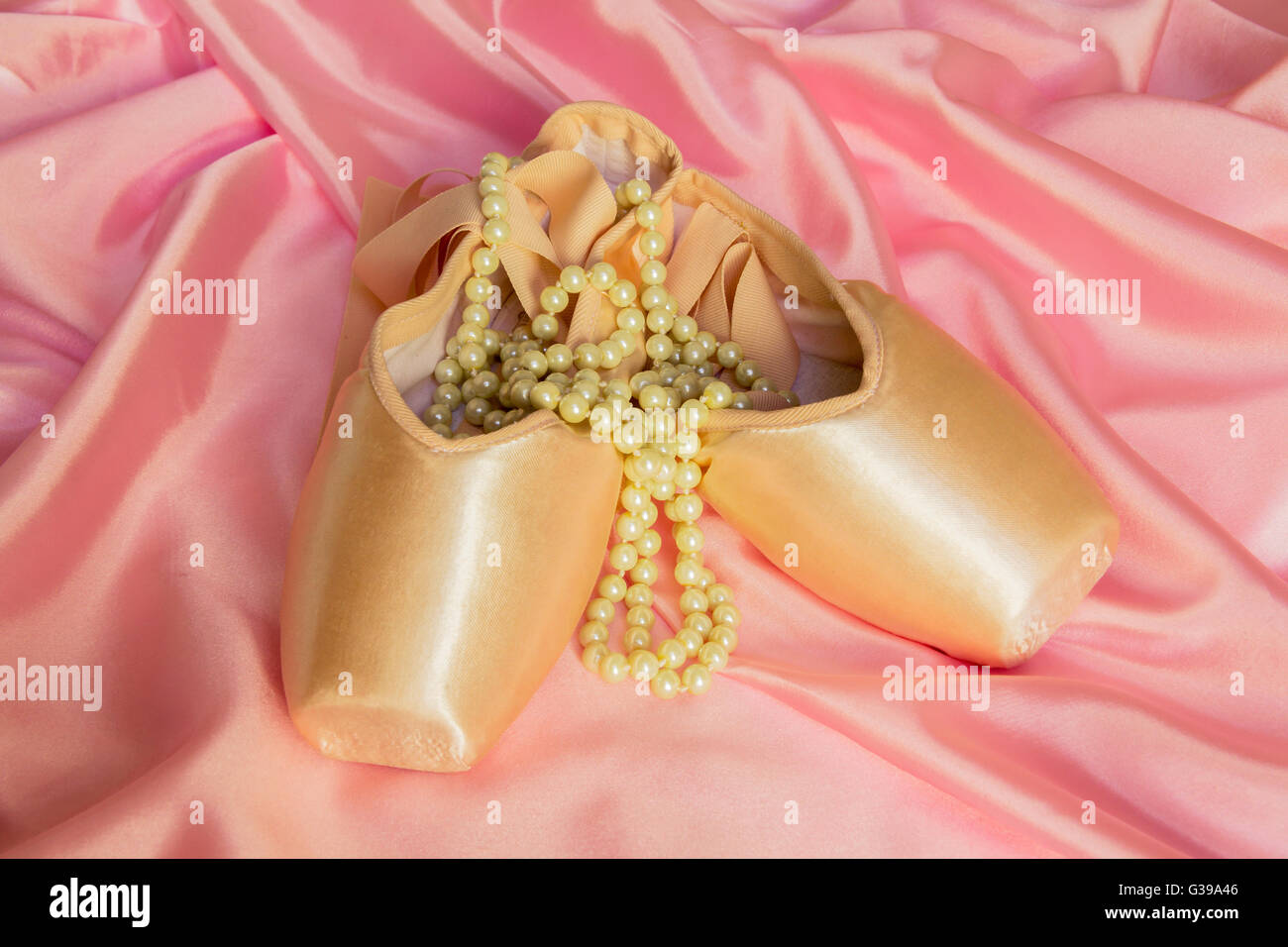Ballet shoes on delicate pink silk background Stock Photo - Alamy