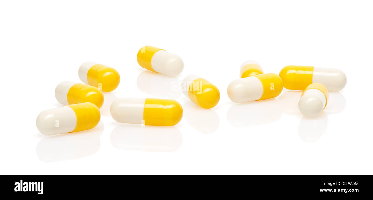 Pile of yellow and white capsules isolated on white background ...