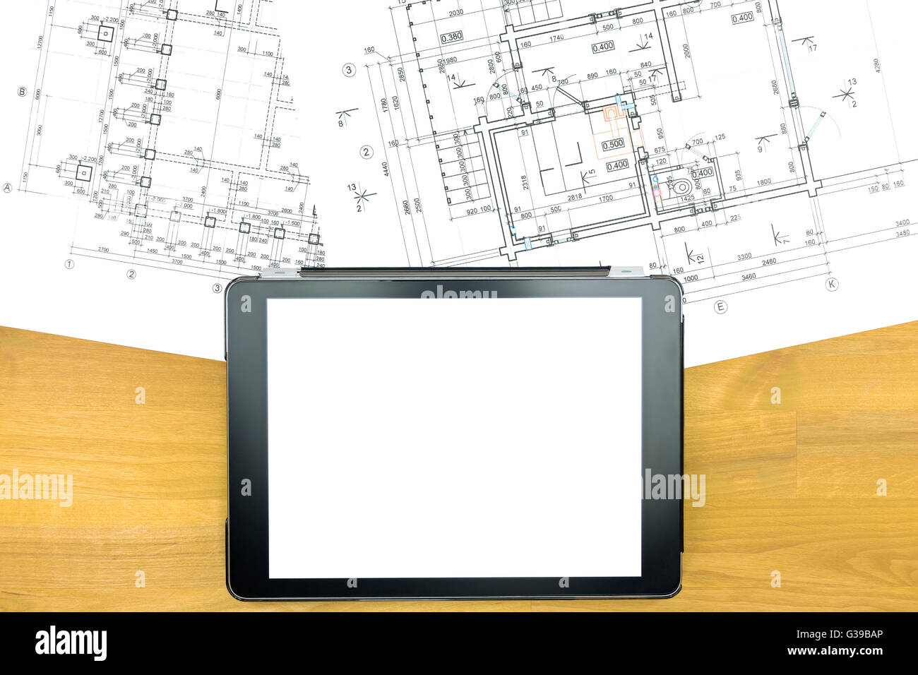 blank digital tablet and construction plans on wooden table Stock Photo ...