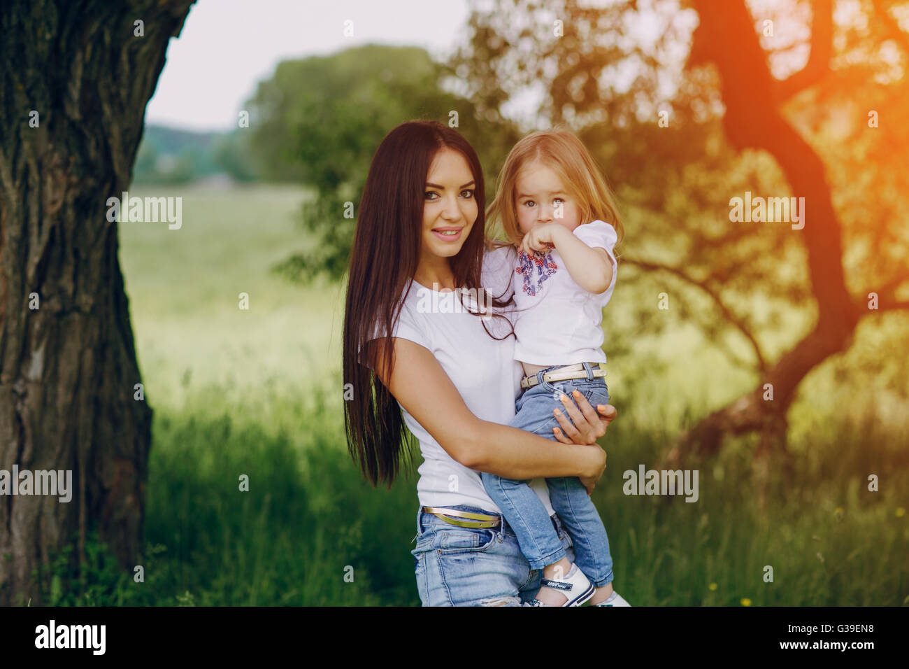 child near tree with mom Stock Photo - Alamy