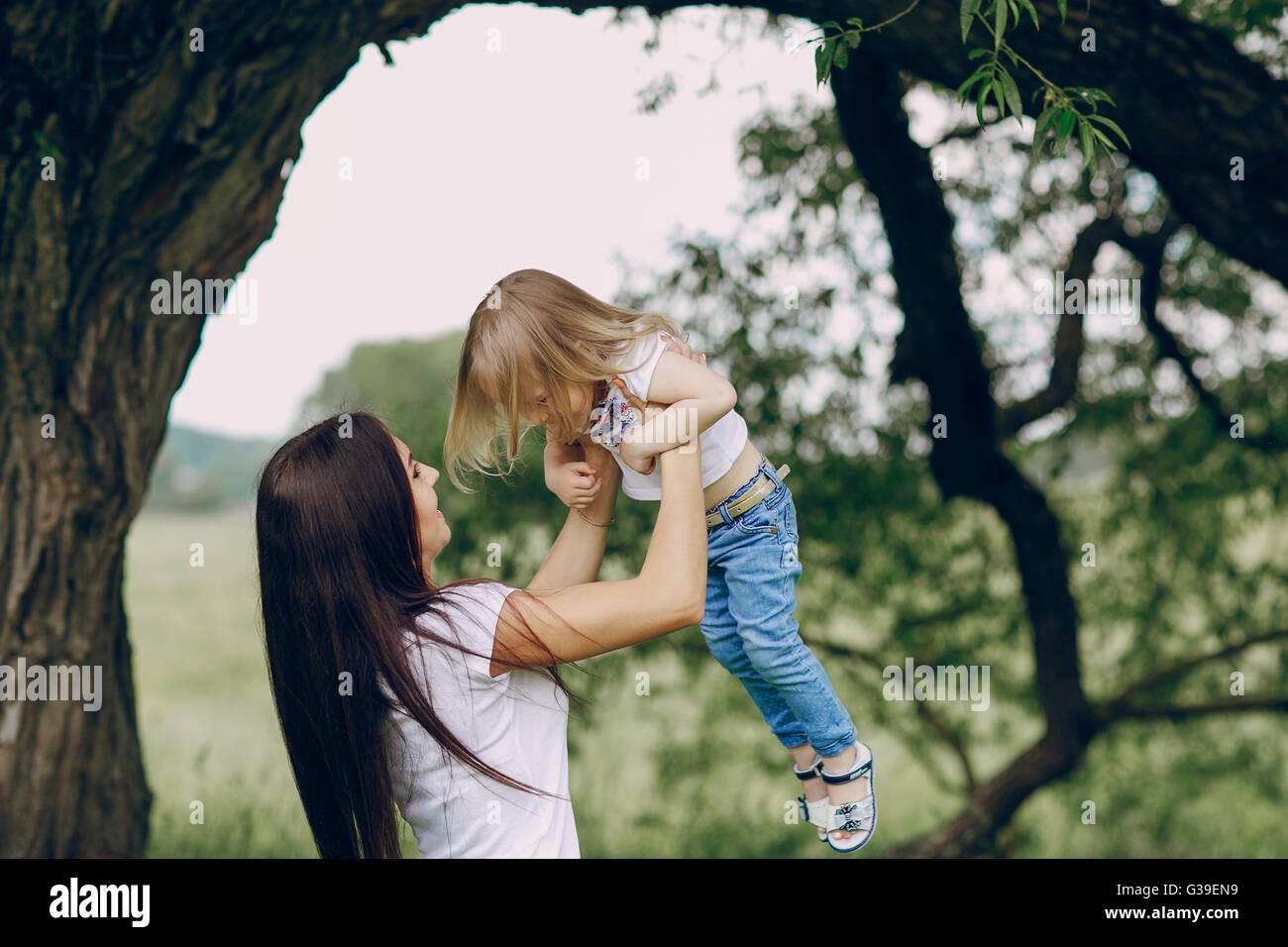 child near tree with mom Stock Photo - Alamy