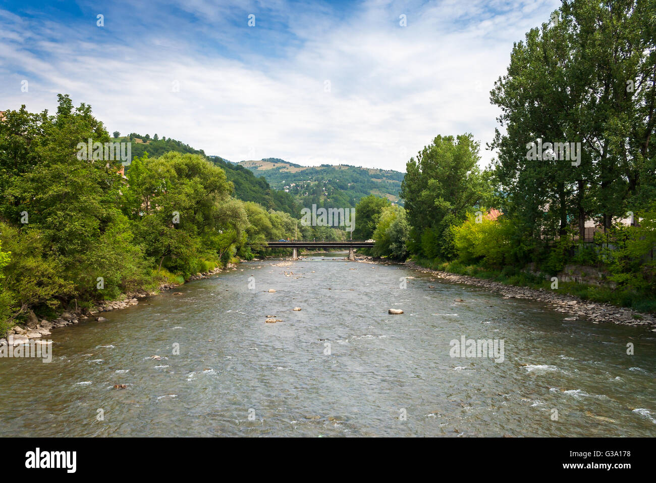 landscape with mountains trees and a bridge through river Stock Photo ...