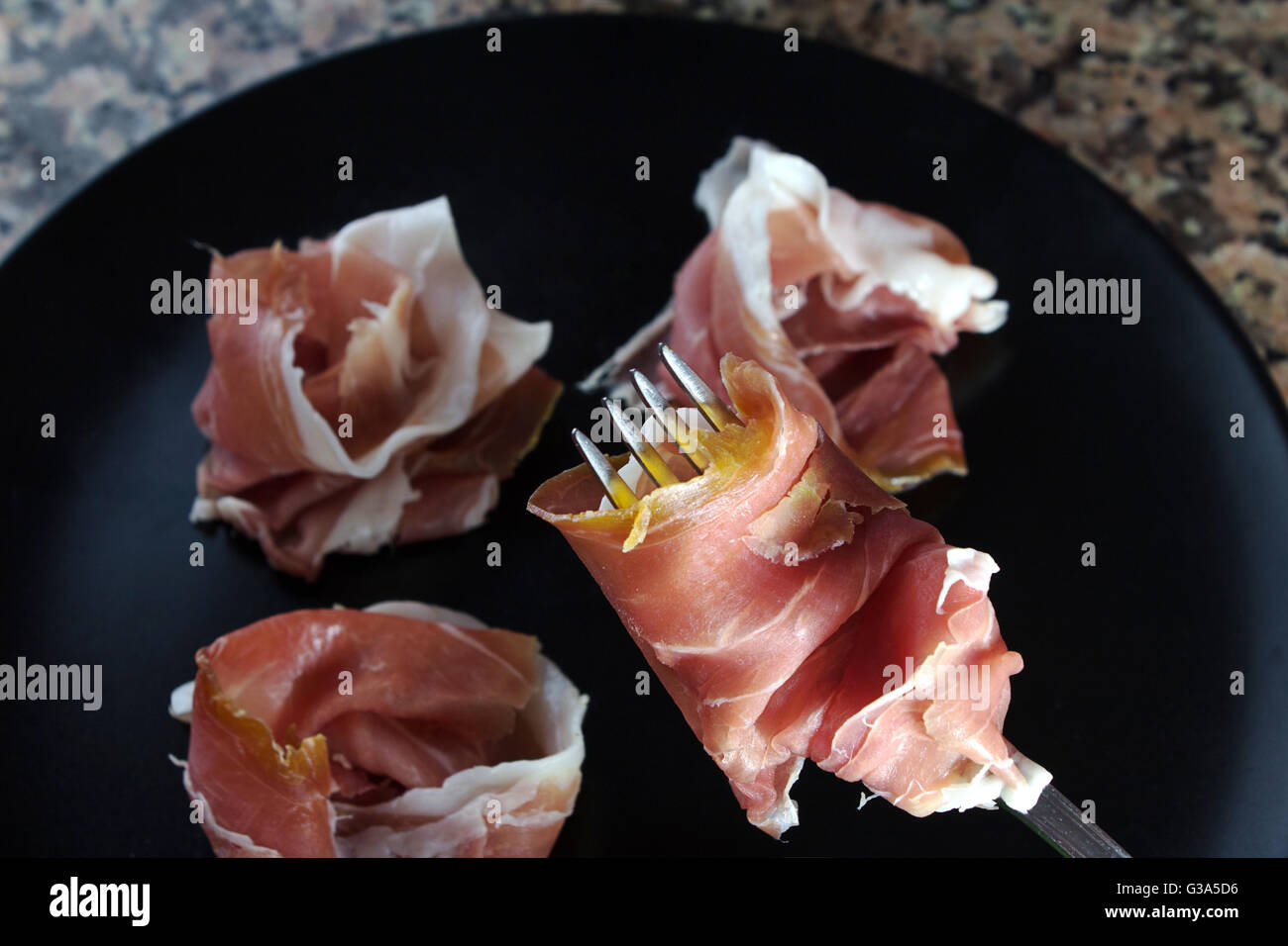 Slices of luxury Parma ham, typical Italian appetizer, with rucola ...