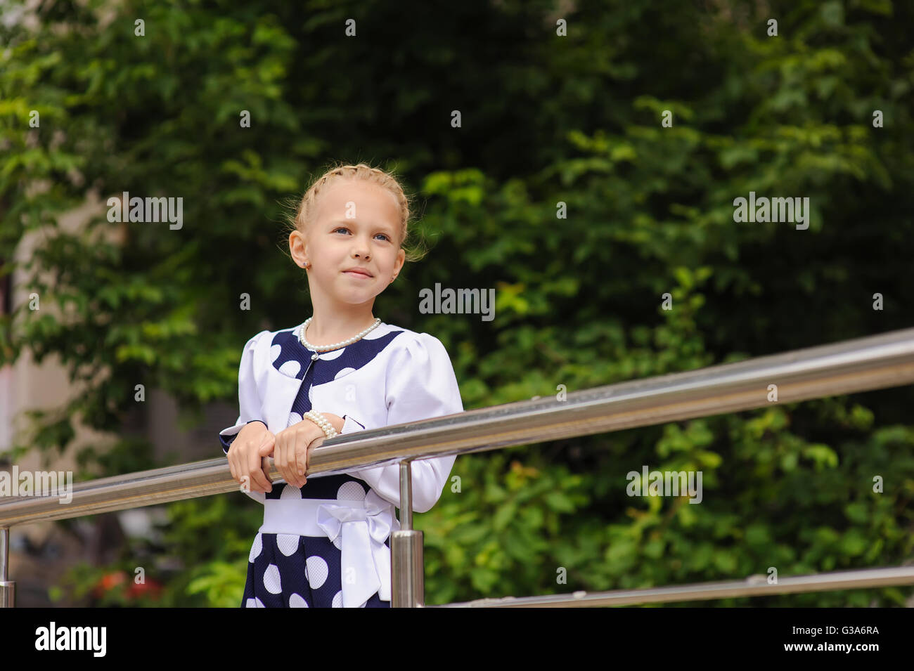 Portrait of a little girl. Child in a beautiful dress looking to side ...